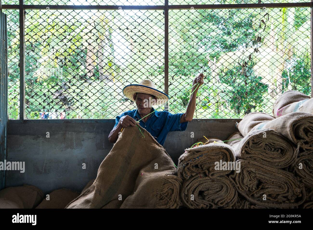 Old Asian man sewing sacks at a rice mill factory Stock Photo - Alamy