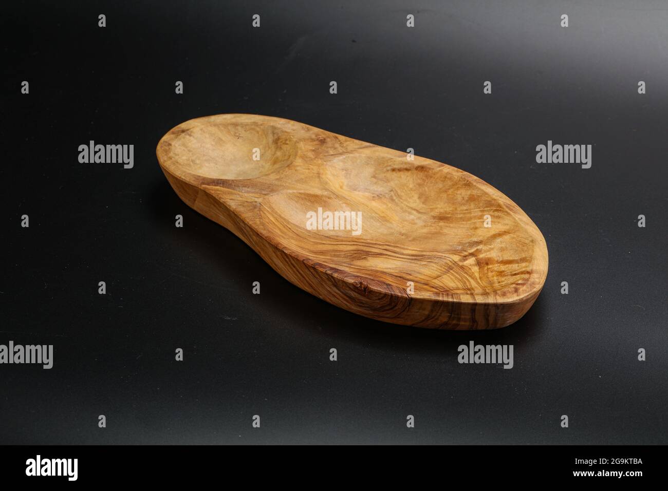 Olive tree board for kitchen over black background Stock Photo - Alamy