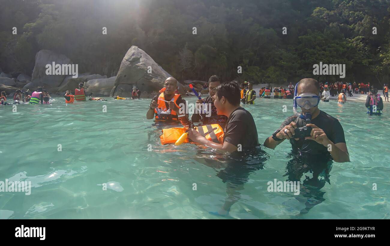A group of guys preparing for snorkeling on an island Stock Photo - Alamy