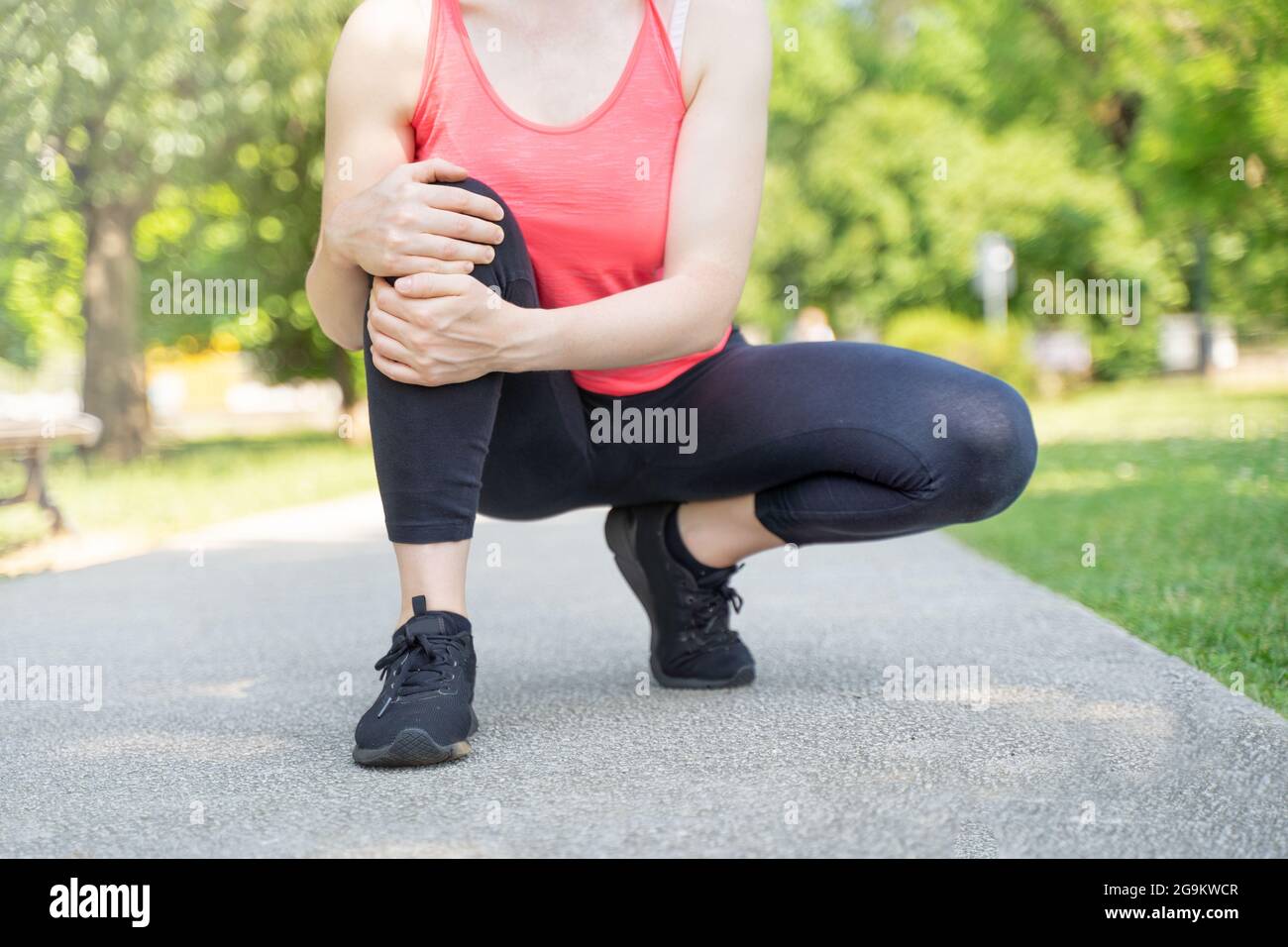 One woman runner hold her injured leg and knee Stock Photo - Alamy