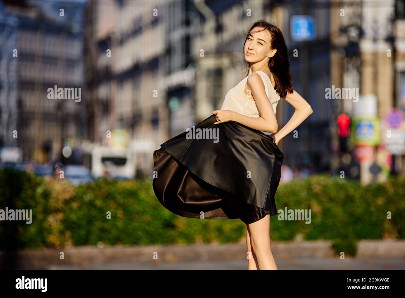 Slim happy girl stands in city center while walking Stock Photo - Alamy