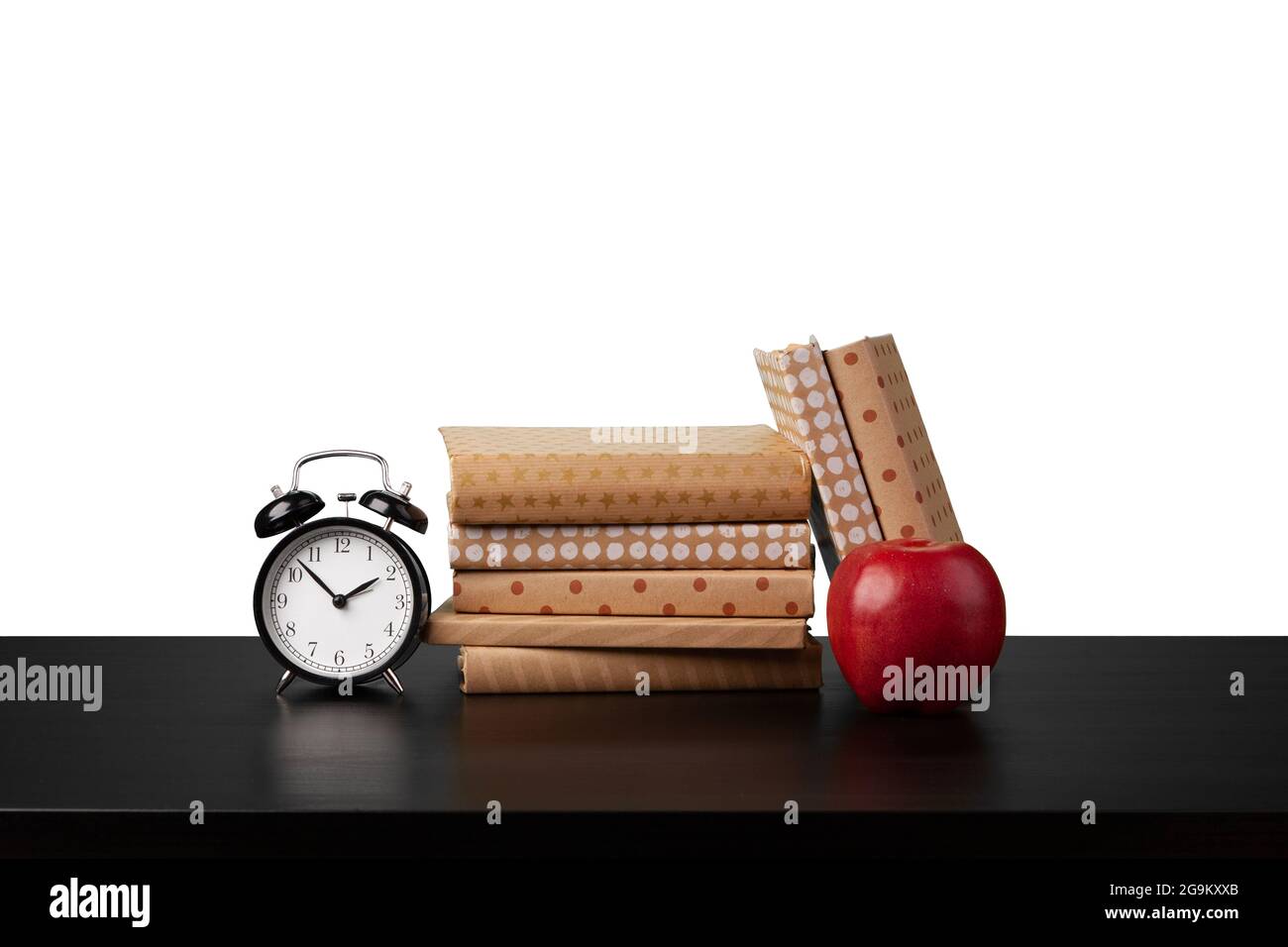 Stack of books and apple on tabletop against white background Stock ...