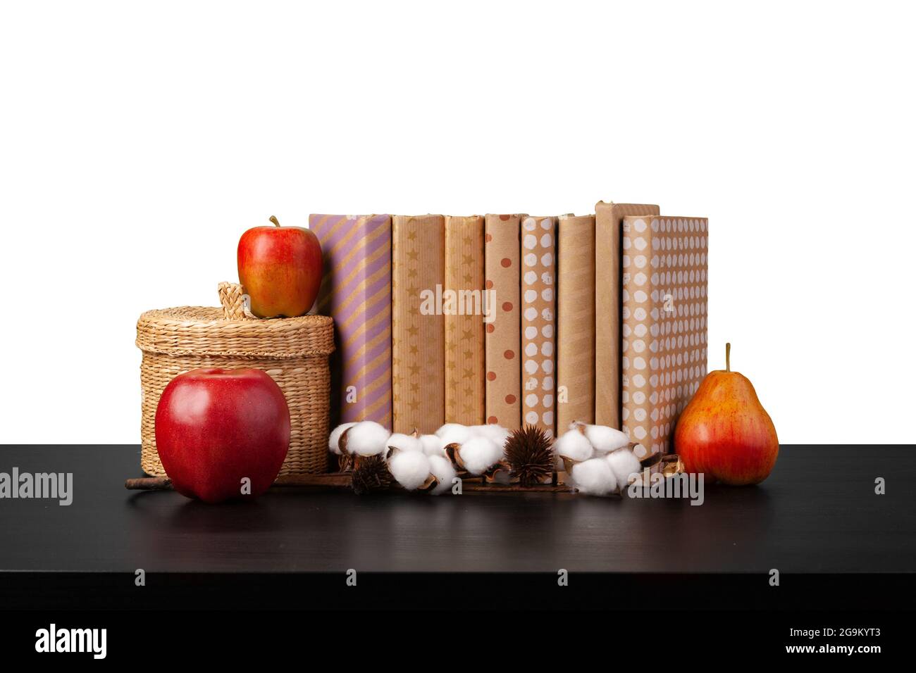 Stack of books and apple on tabletop against white background Stock ...