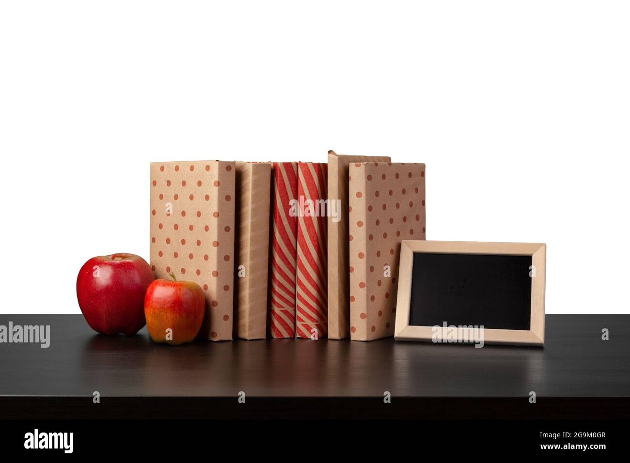 Stack of books and apple on tabletop against white background Stock ...
