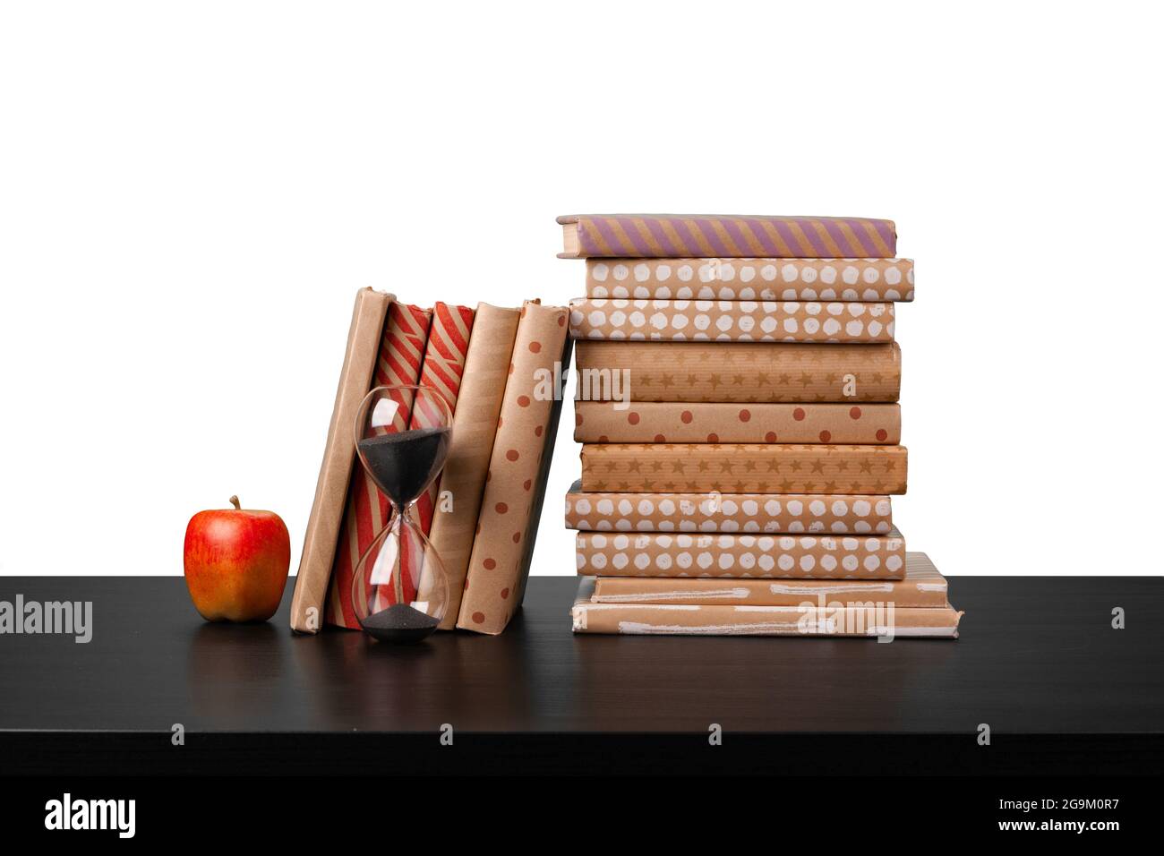 Stack of books and apple on tabletop against white background Stock ...