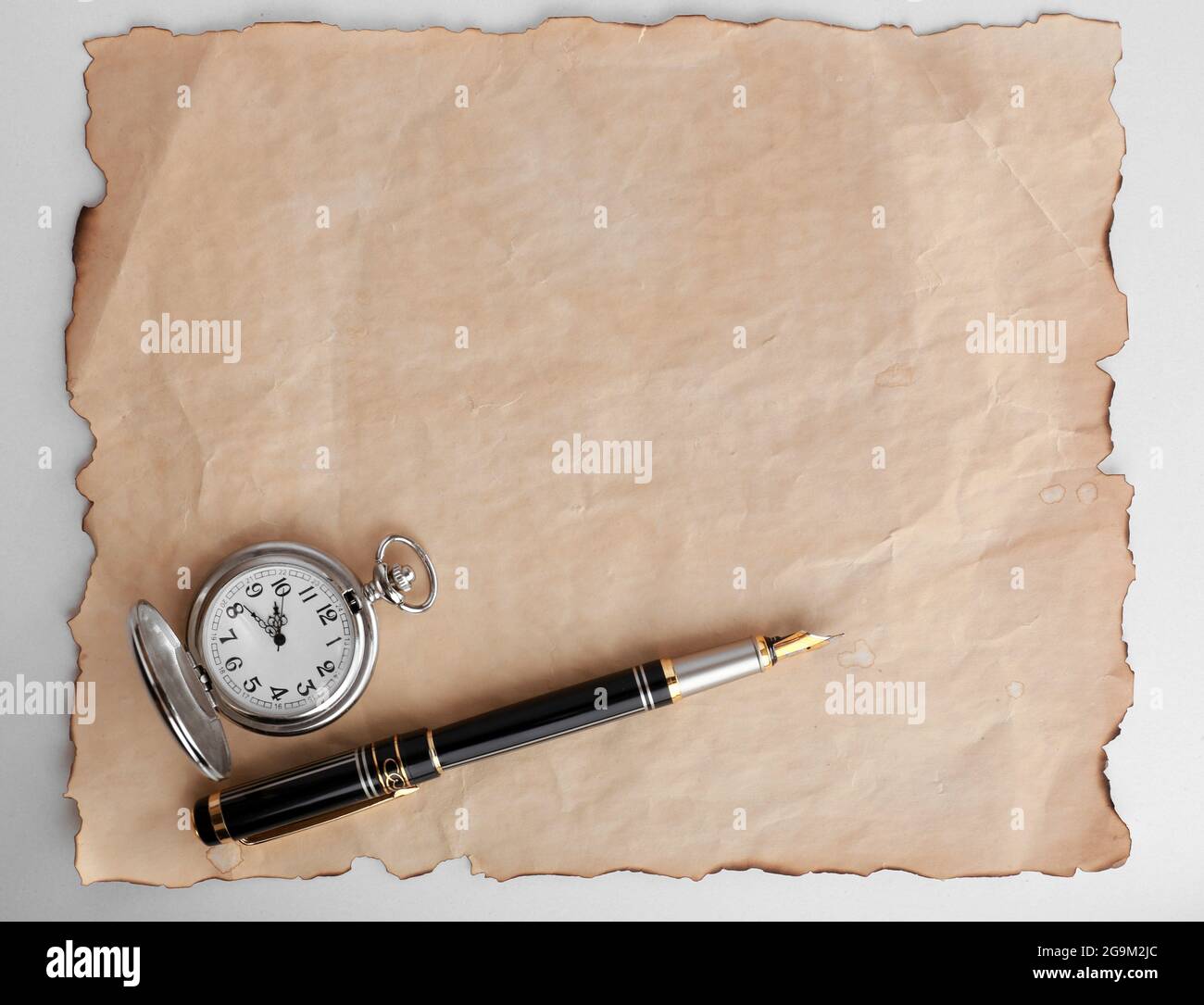 Silver pocket clock on old paper background Stock Photo - Alamy