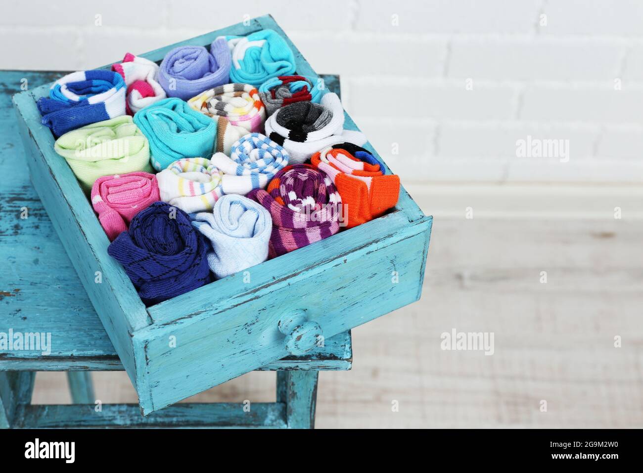 Socks in color drawer on white brick wall background Stock Photo - Alamy