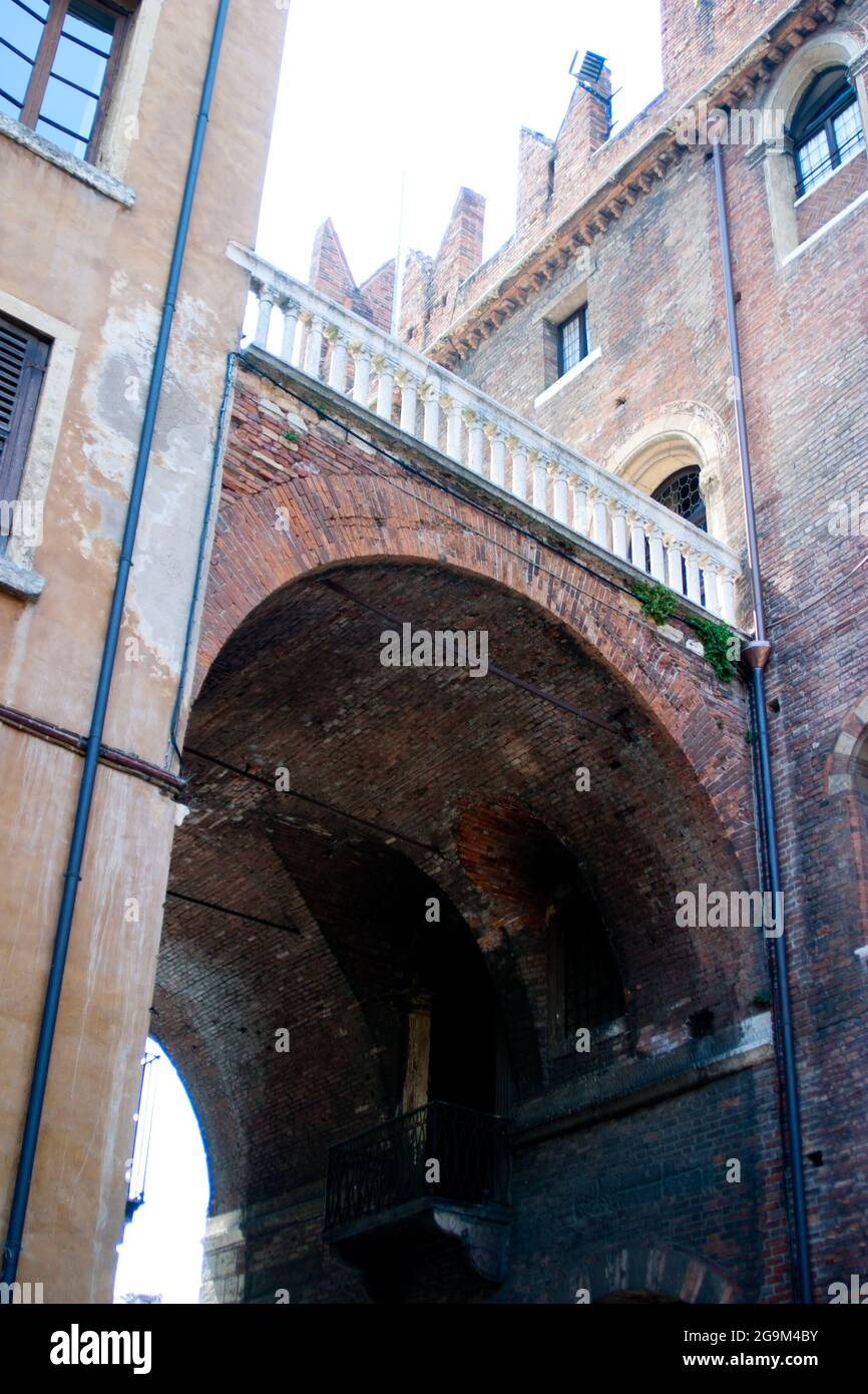 Portrait of a brickwork arch bridge between two buildings in a Tuscan ...