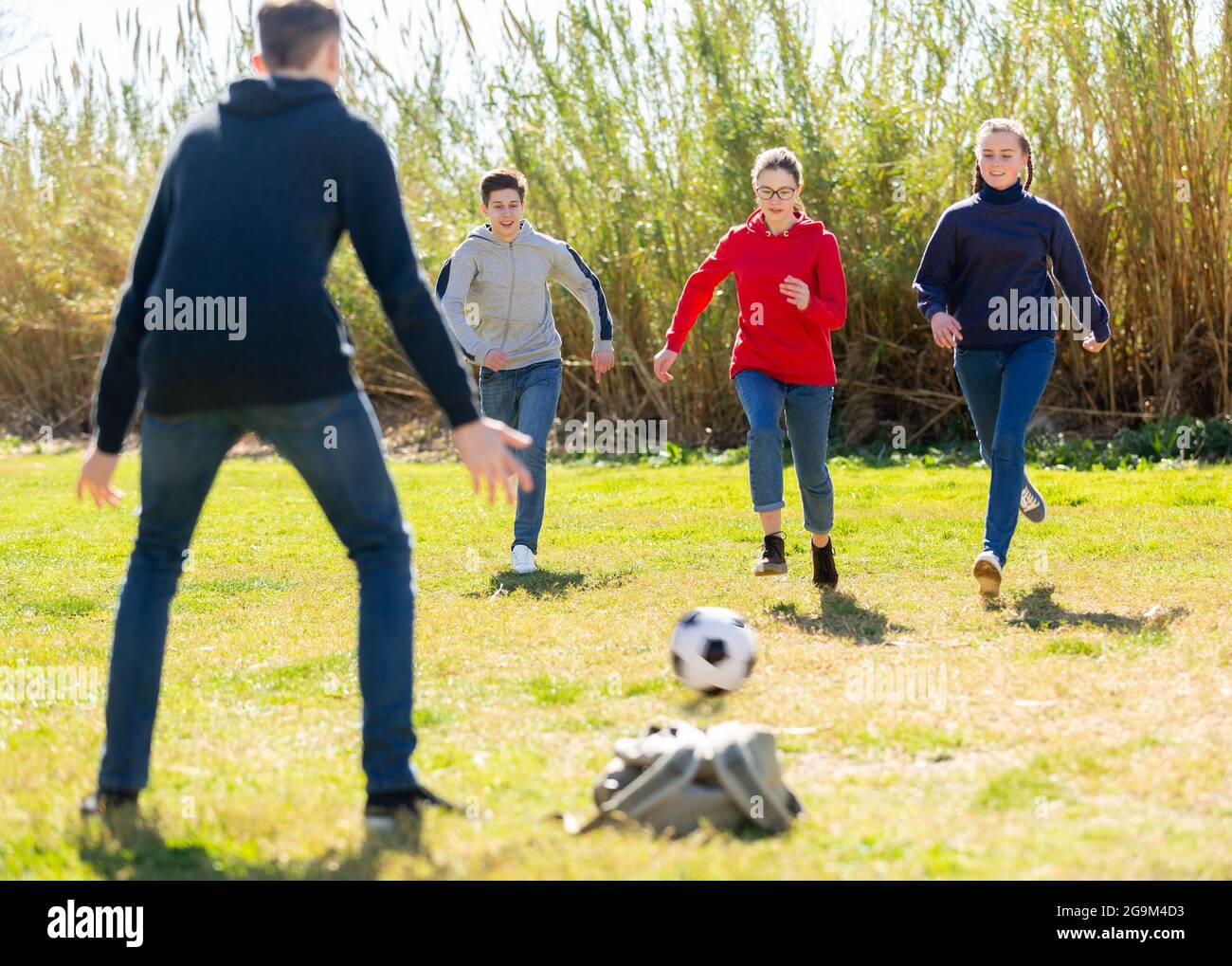 Teenagers play street football with excitement Stock Photo - Alamy