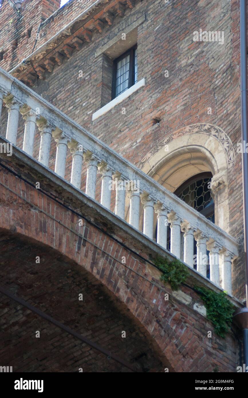 Portrait of a brickwork arch bridge between two buildings in a Tuscan ...