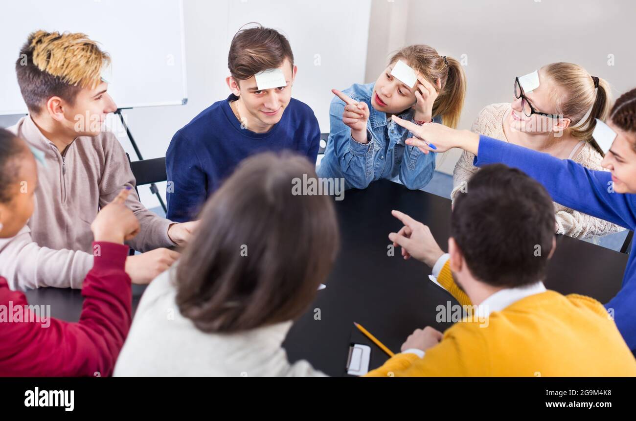 Fellow students playing a guess-who game during school day Stock Photo ...