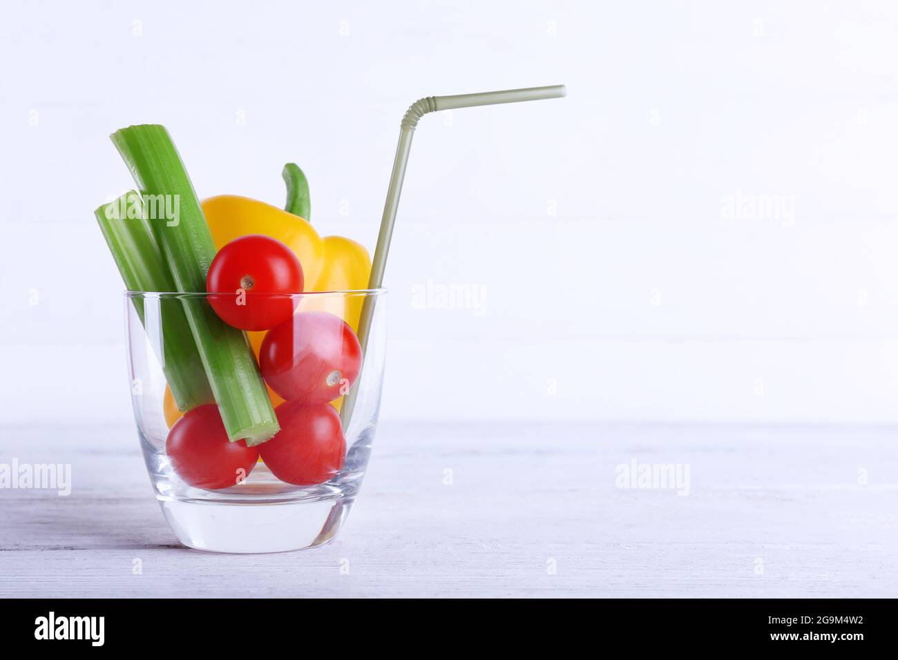 Vegetables in glass with tube on color wooden planks background Stock ...