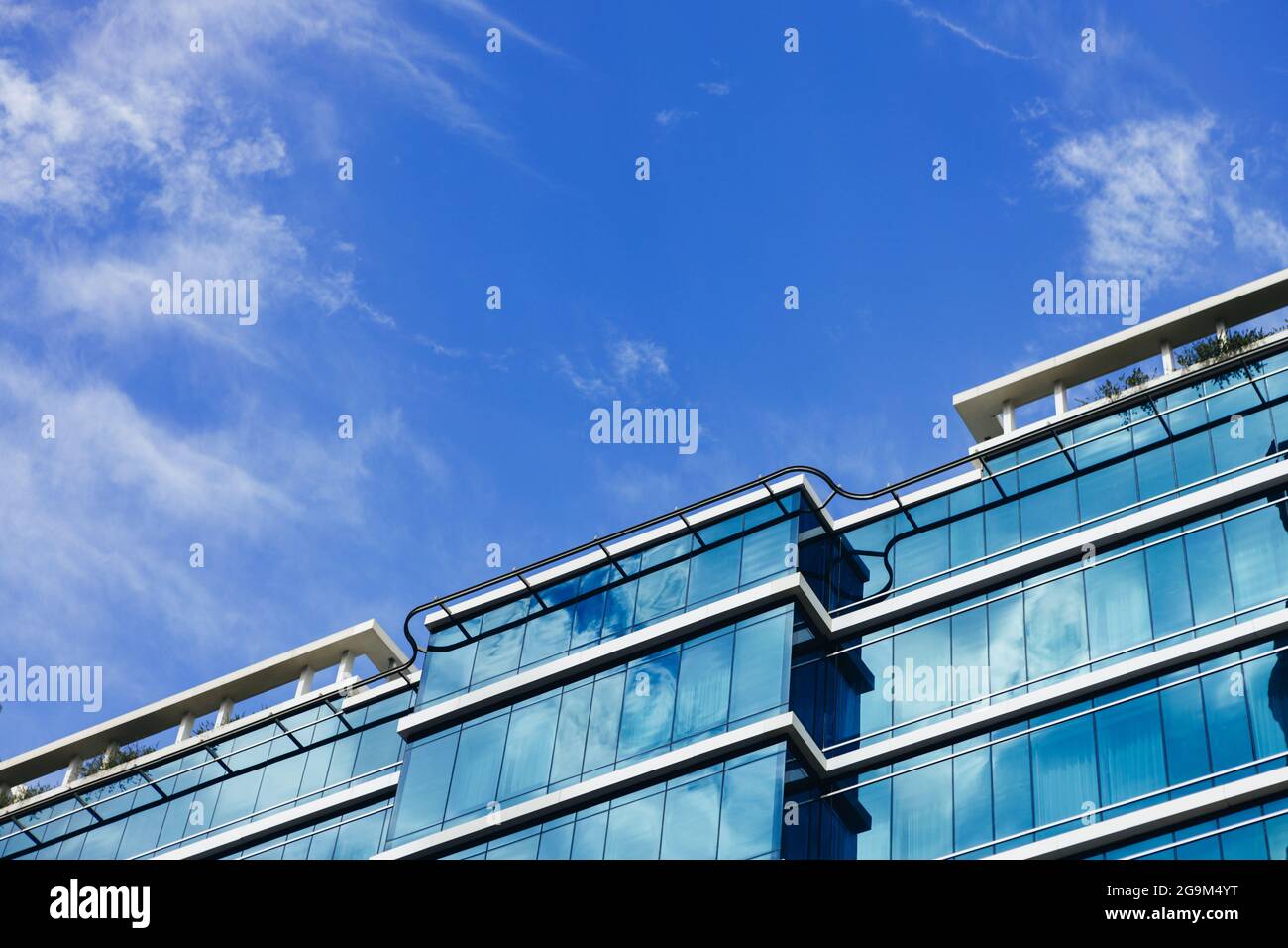 Glass skyscraper building with cloudy blue sky background Stock Photo ...