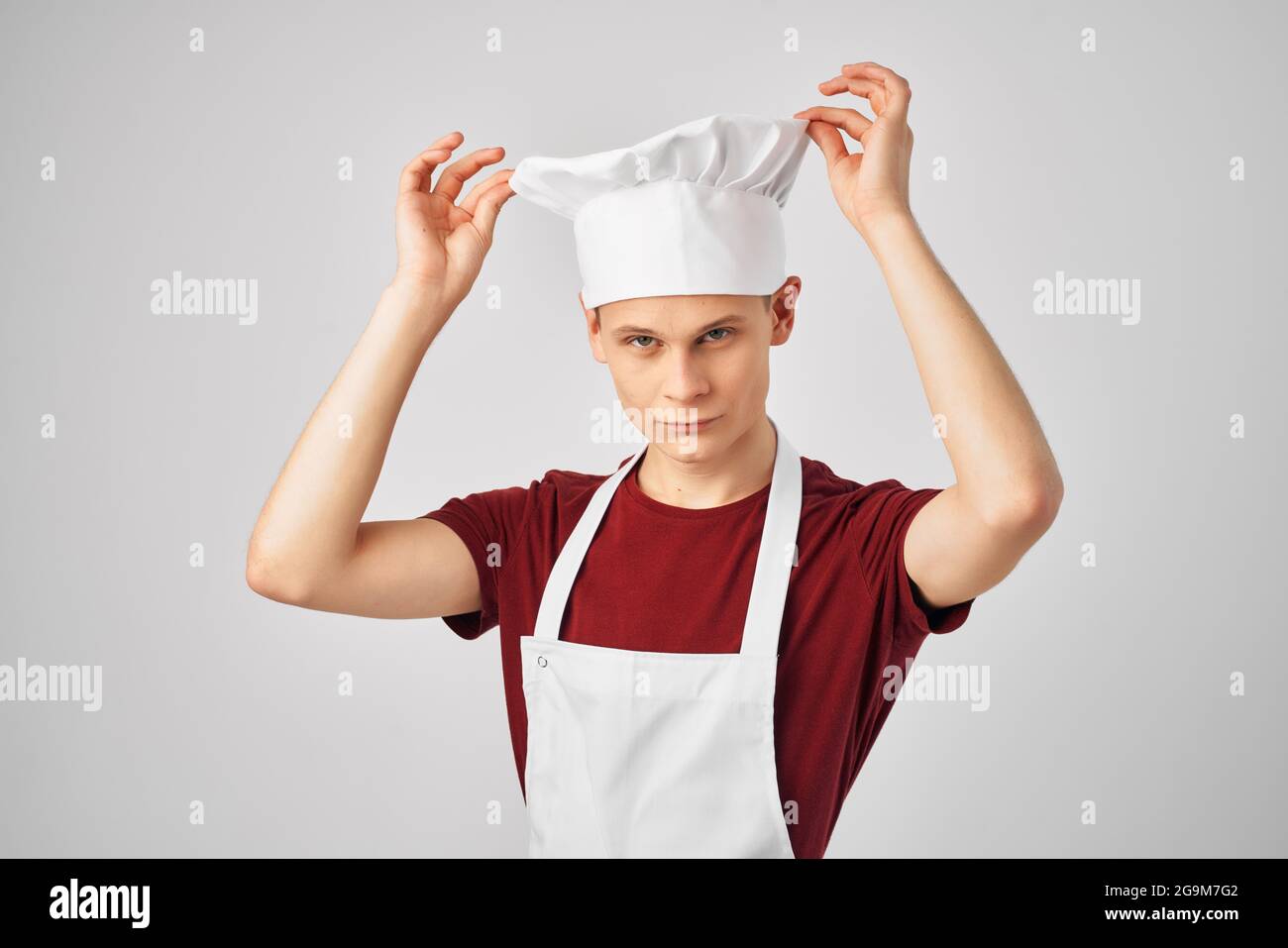 male chef with a cap on his head kitchen professionals light background ...