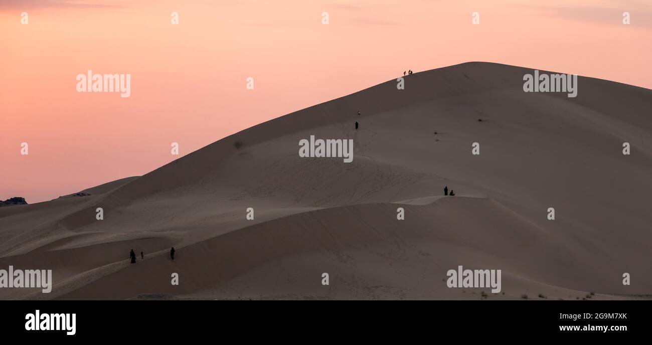 Panoramic view of people climbing the huge sand dunes in Badr, Medina ...