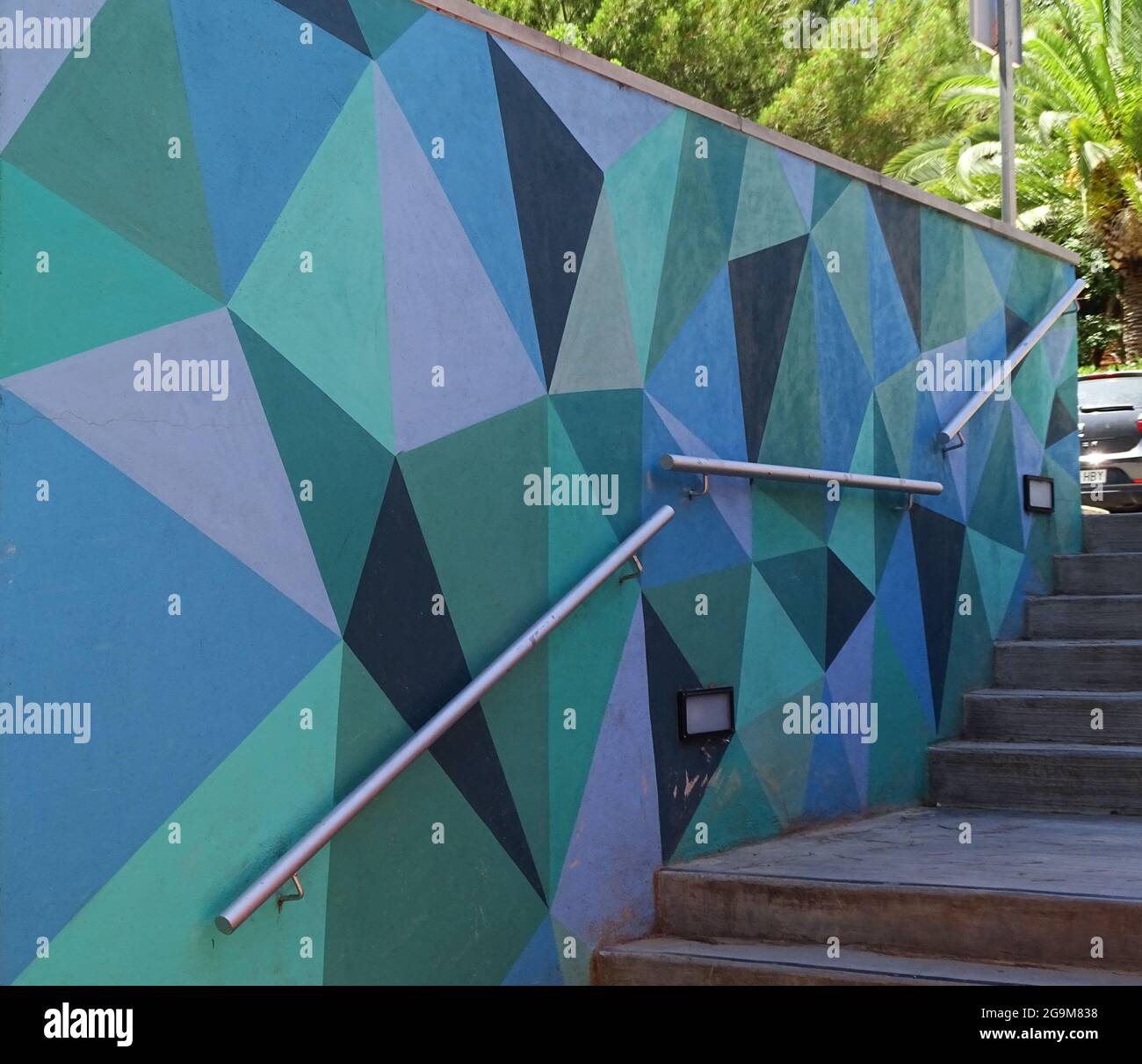 Wall of underpass painted with triangles in different monochrome colors ...