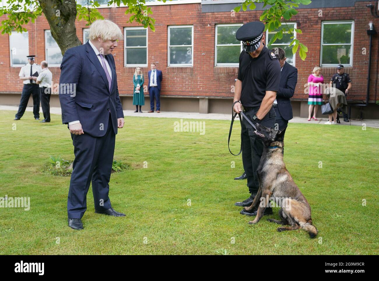 Prime Minister Boris Johnson speaks to a police dog handler during a ...