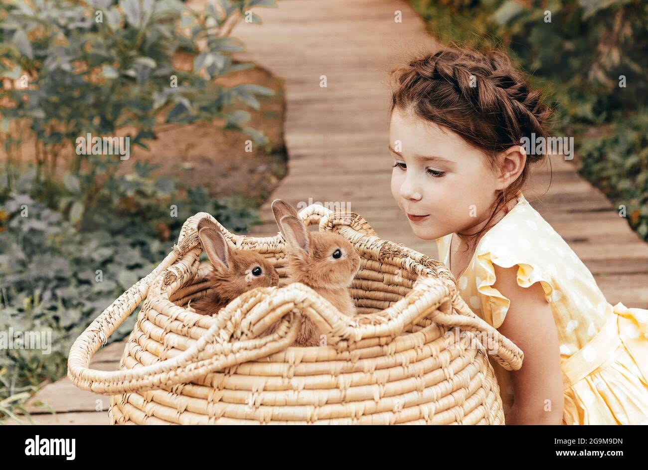 Little pretty girl in summer dress sitting outside on wooden path in ...