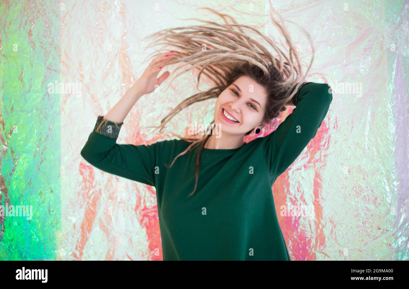 Cheerful young female in colorful outfit looking at camera with smile ...