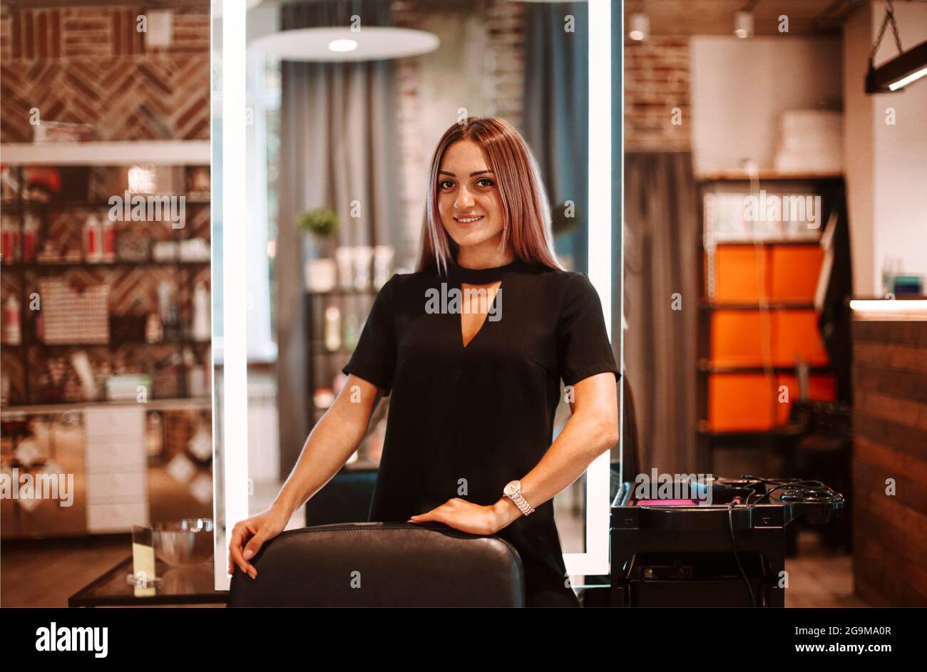 Woman working in hairdressing salon. Portrait of a young and pretty ...