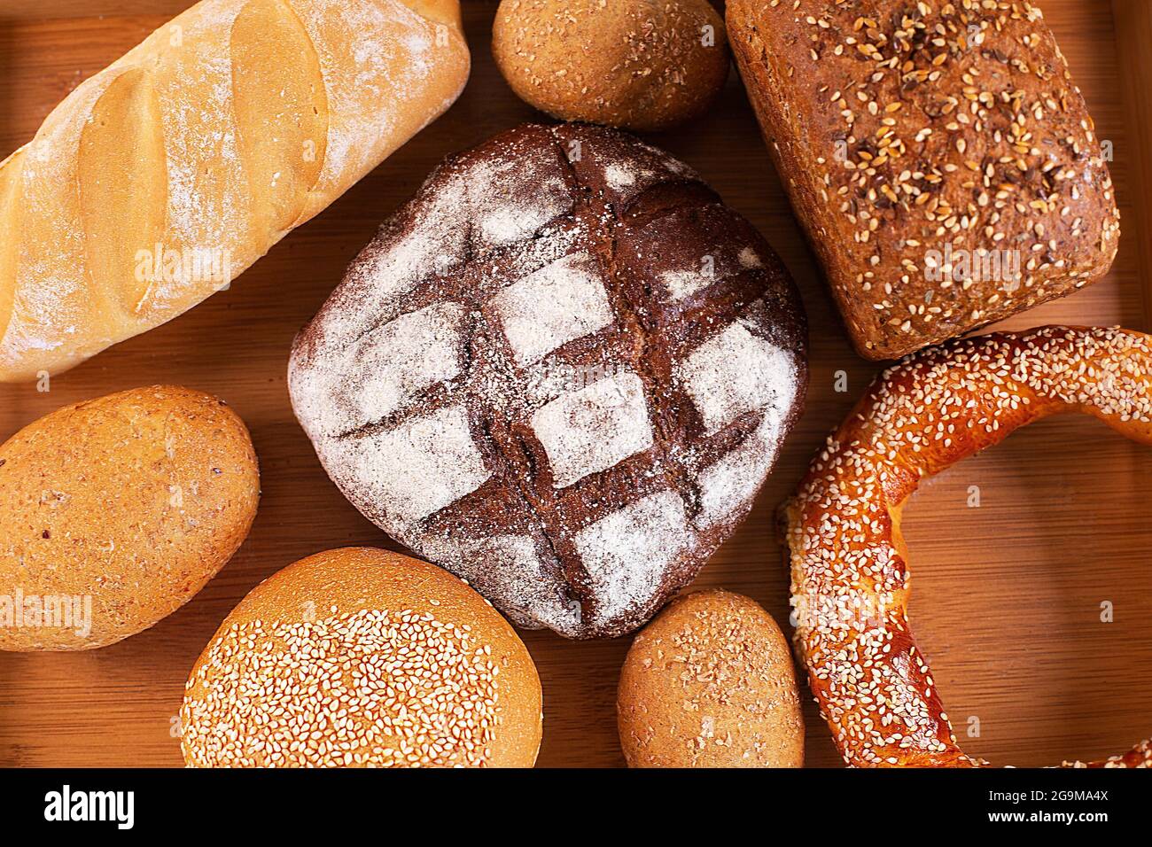 Different kinds of fresh bread and buns on a tray. Bakery rustic ...