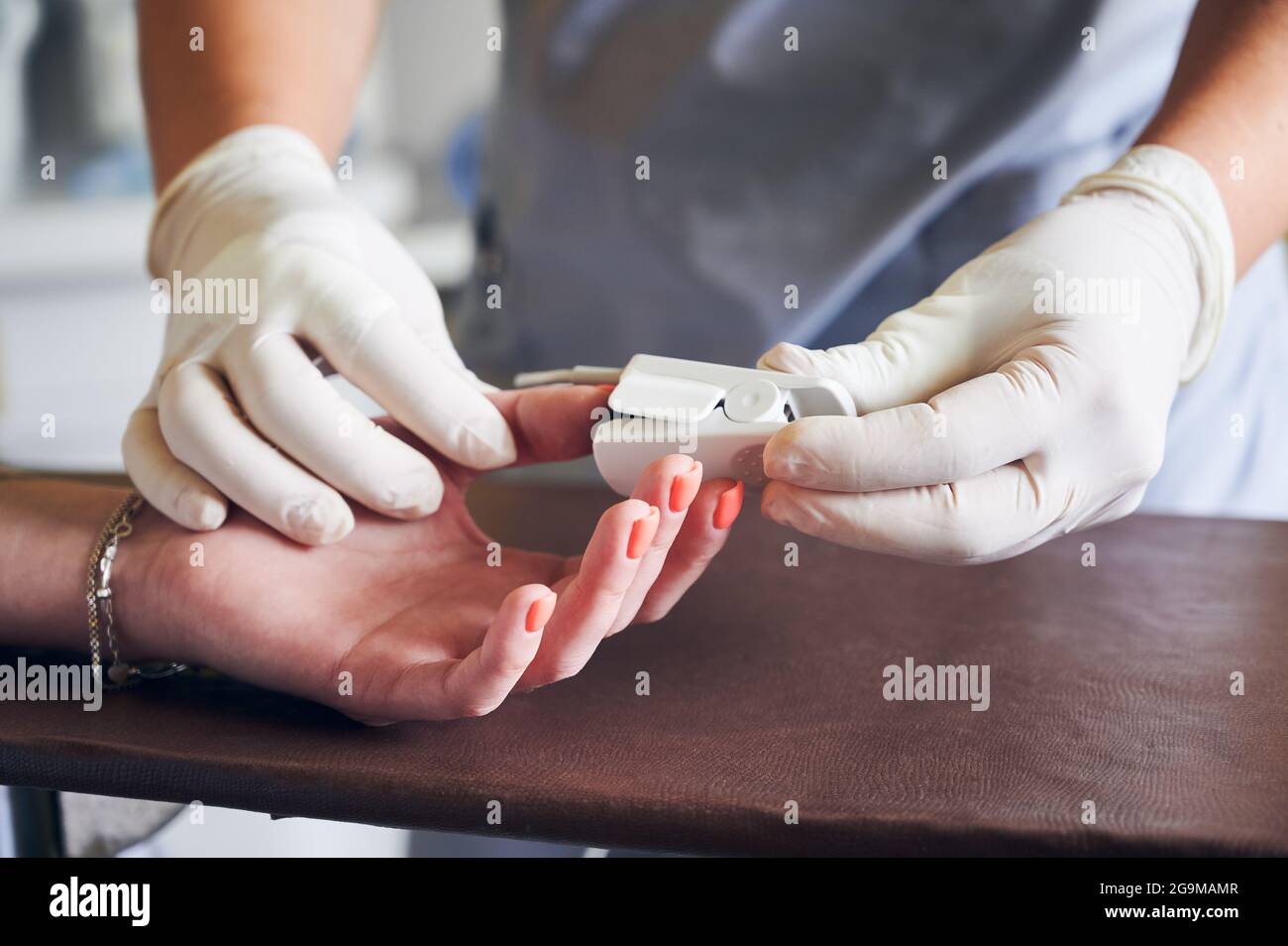 Close up of medical worker hands placing pulse oximeter sensor on woman ...