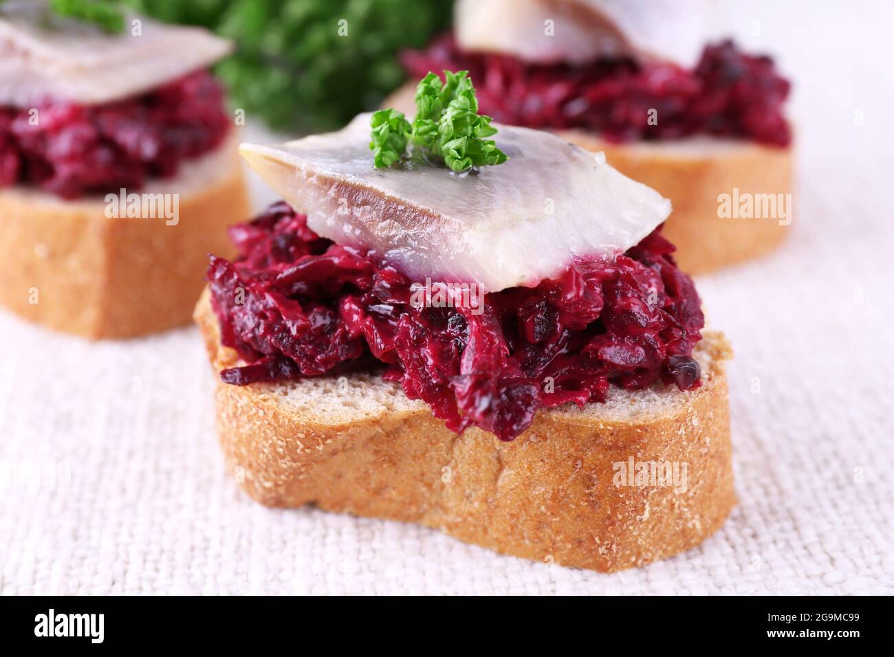 Rye toasts with herring and beets on tablecloth background Stock Photo ...
