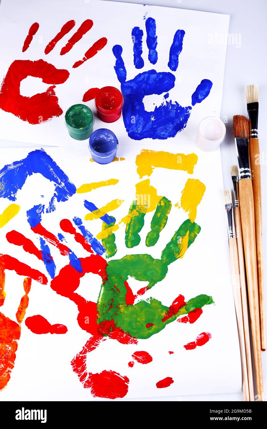 Hand prints of paint, paints and brushes on white background Stock ...