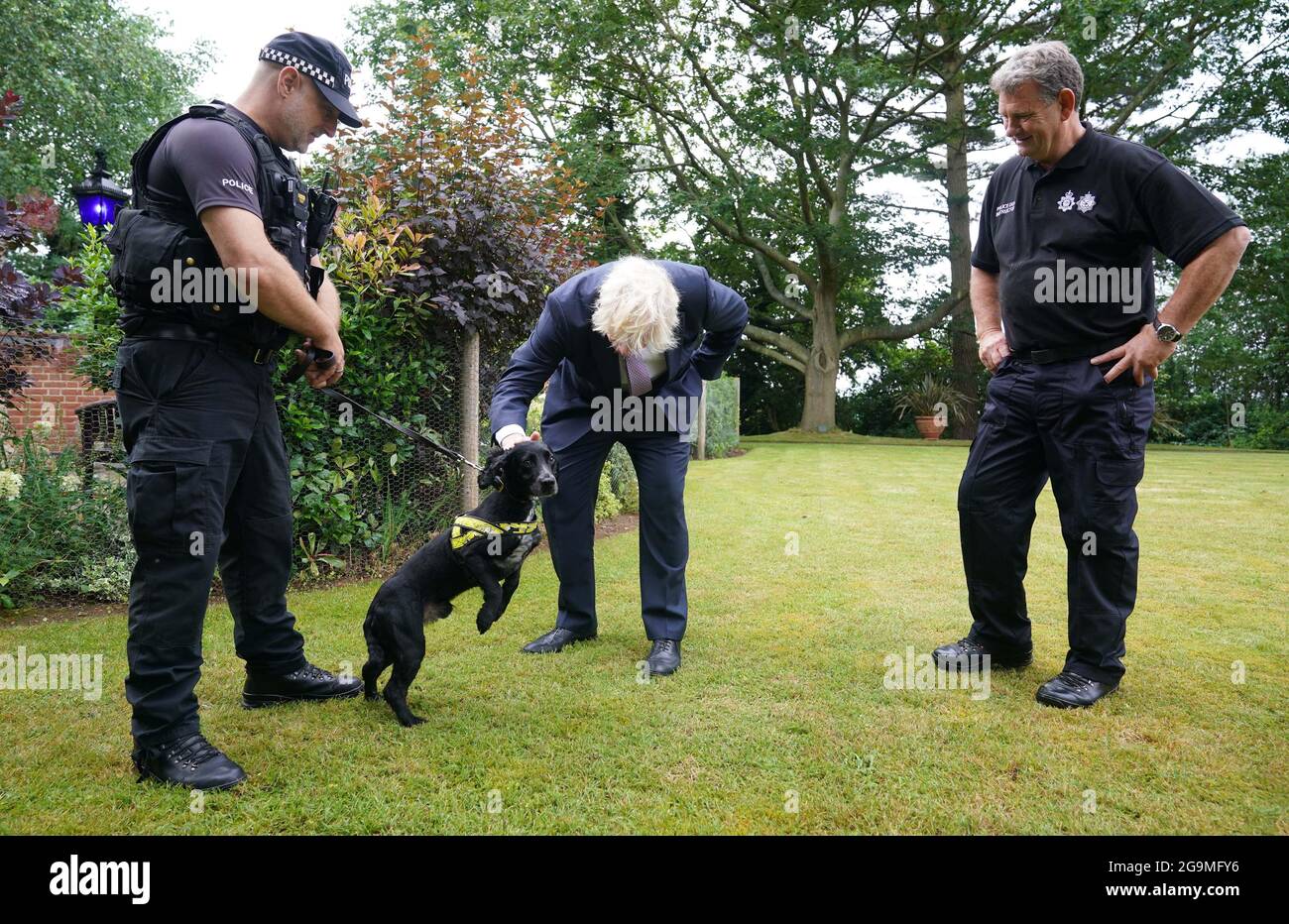 Prime Minister Boris Johnson speaks to a police dog handler during a ...
