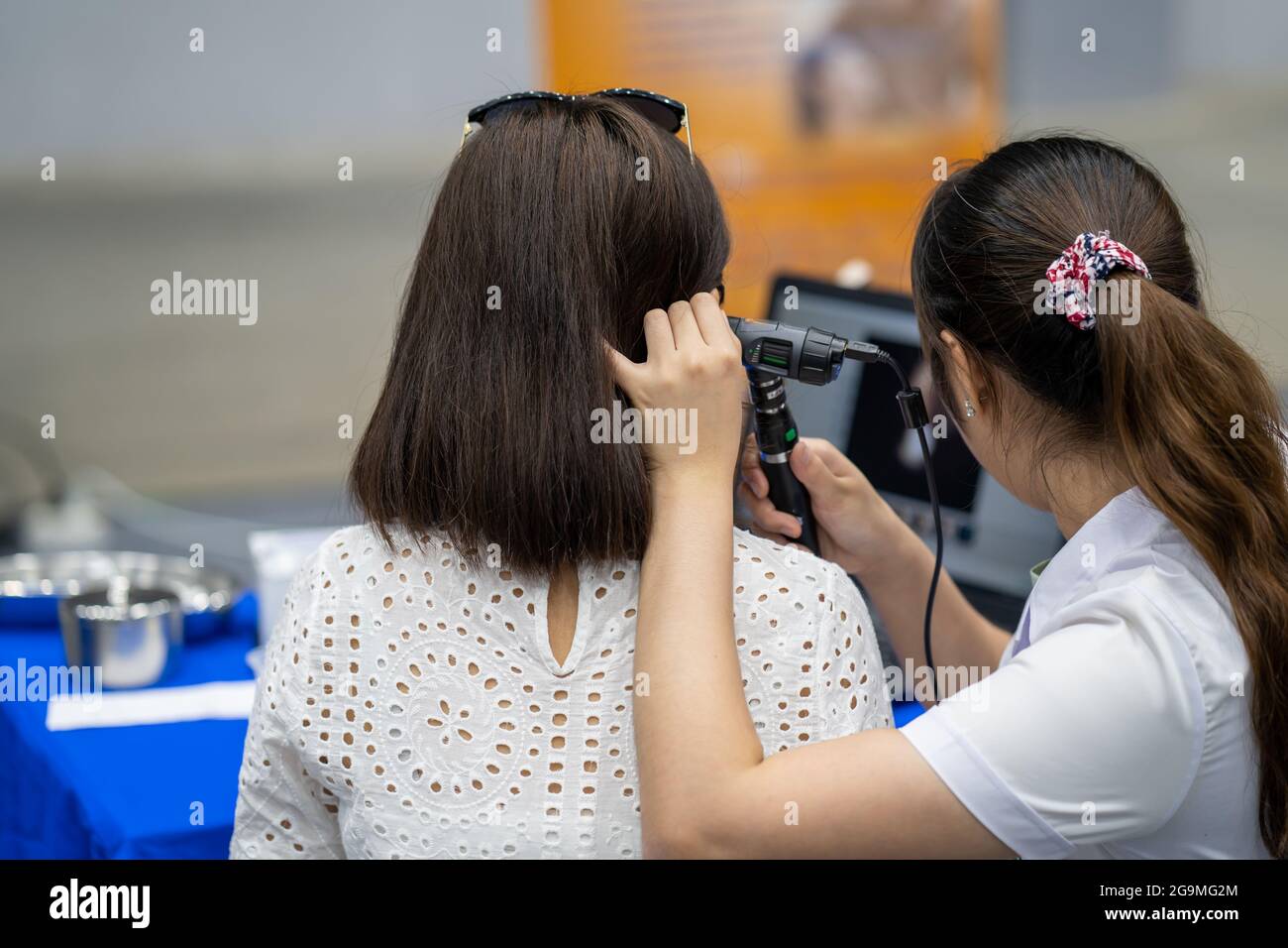 Back view of a female at an ear check-up Stock Photo - Alamy