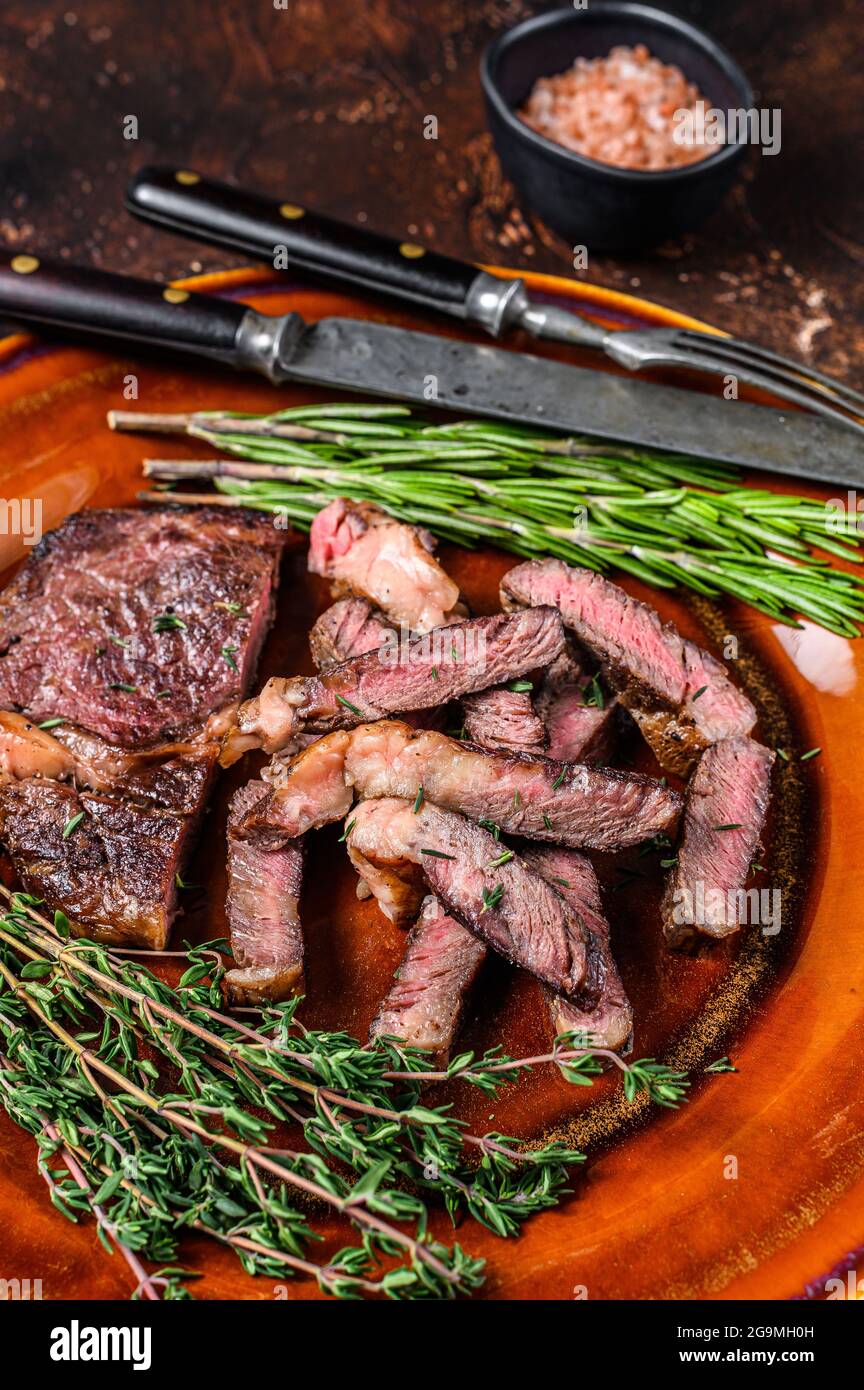 Grilled sliced rib eye or ribeye beef meat steak on a rustic plate ...