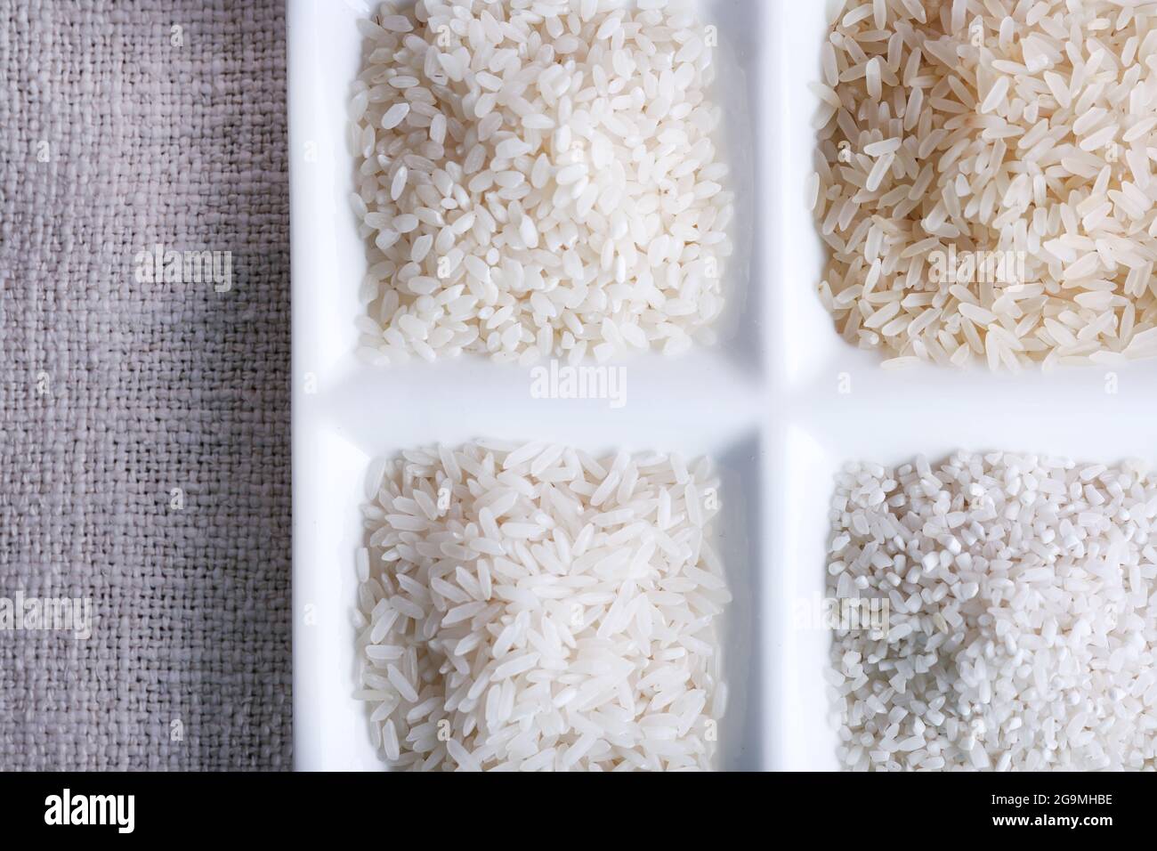 Different types of rice on plate on fabric background Stock Photo - Alamy