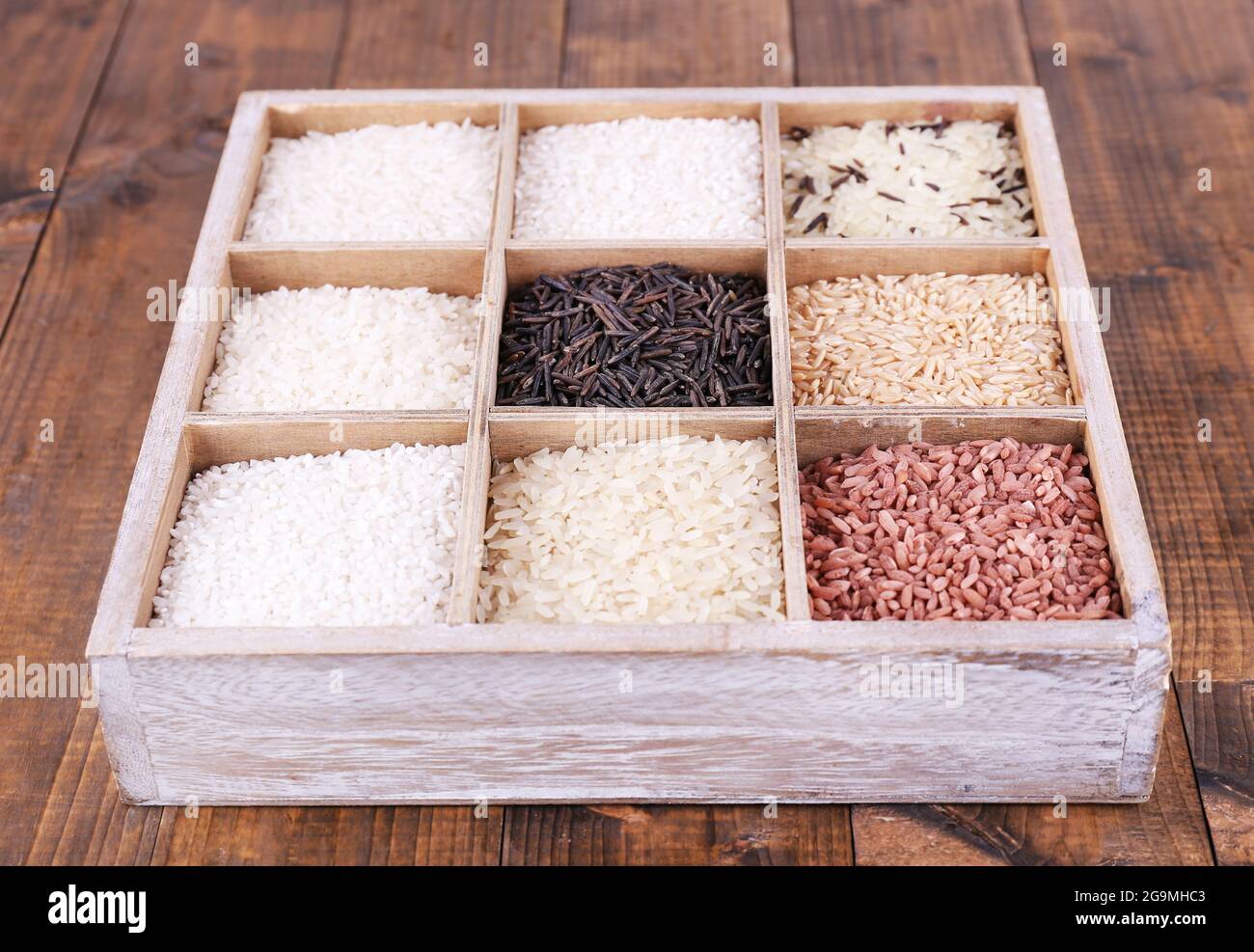 Different types of rice in box on wooden background Stock Photo - Alamy
