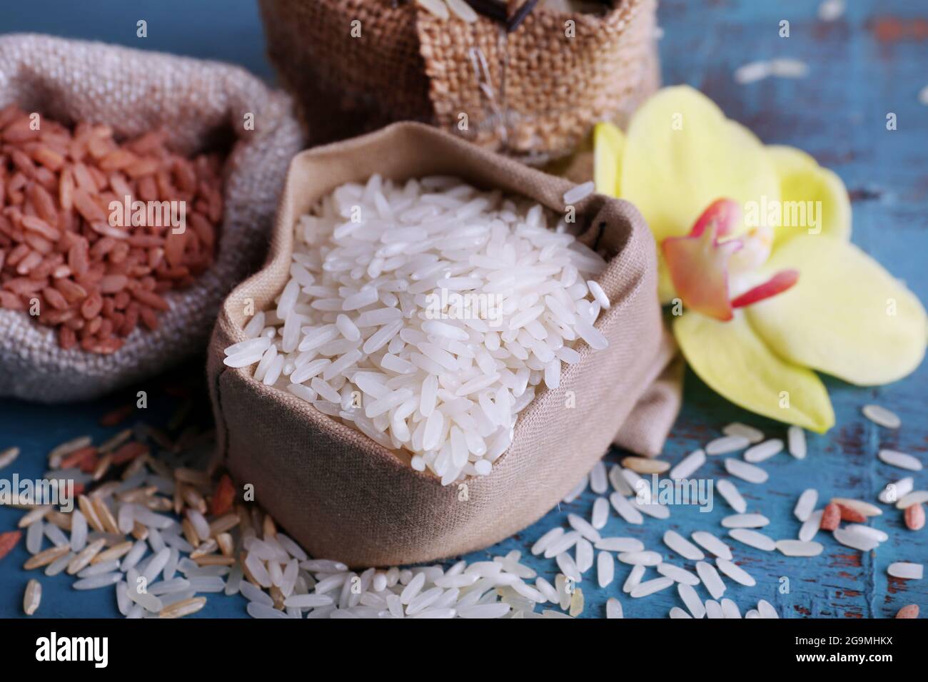 Different types of rice in sacks on wooden background Stock Photo - Alamy