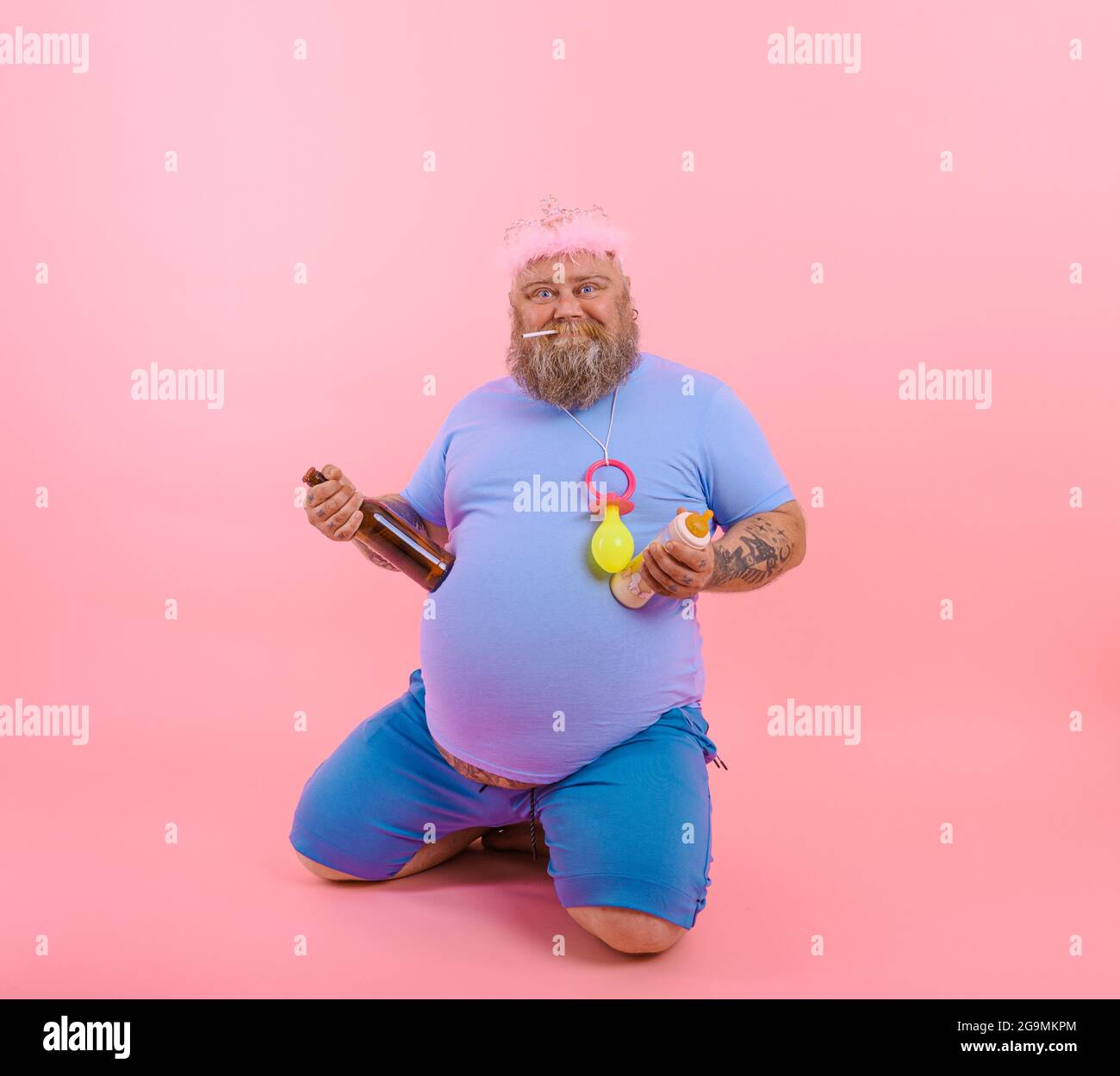 Fat happy man acts like a happy baby but drinks beer Stock Photo - Alamy