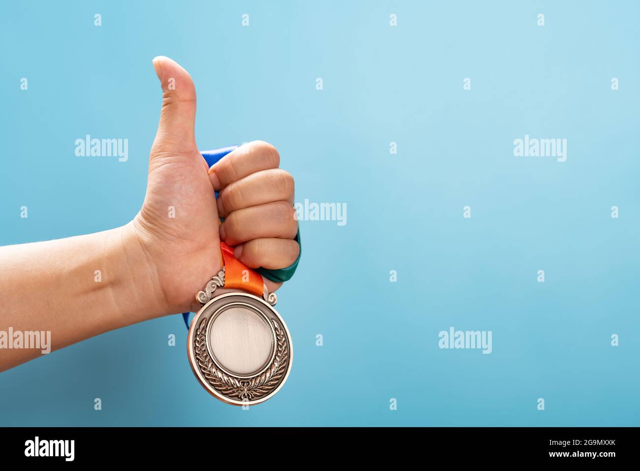 man lifting a bronze medal with the thumb up Stock Photo - Alamy