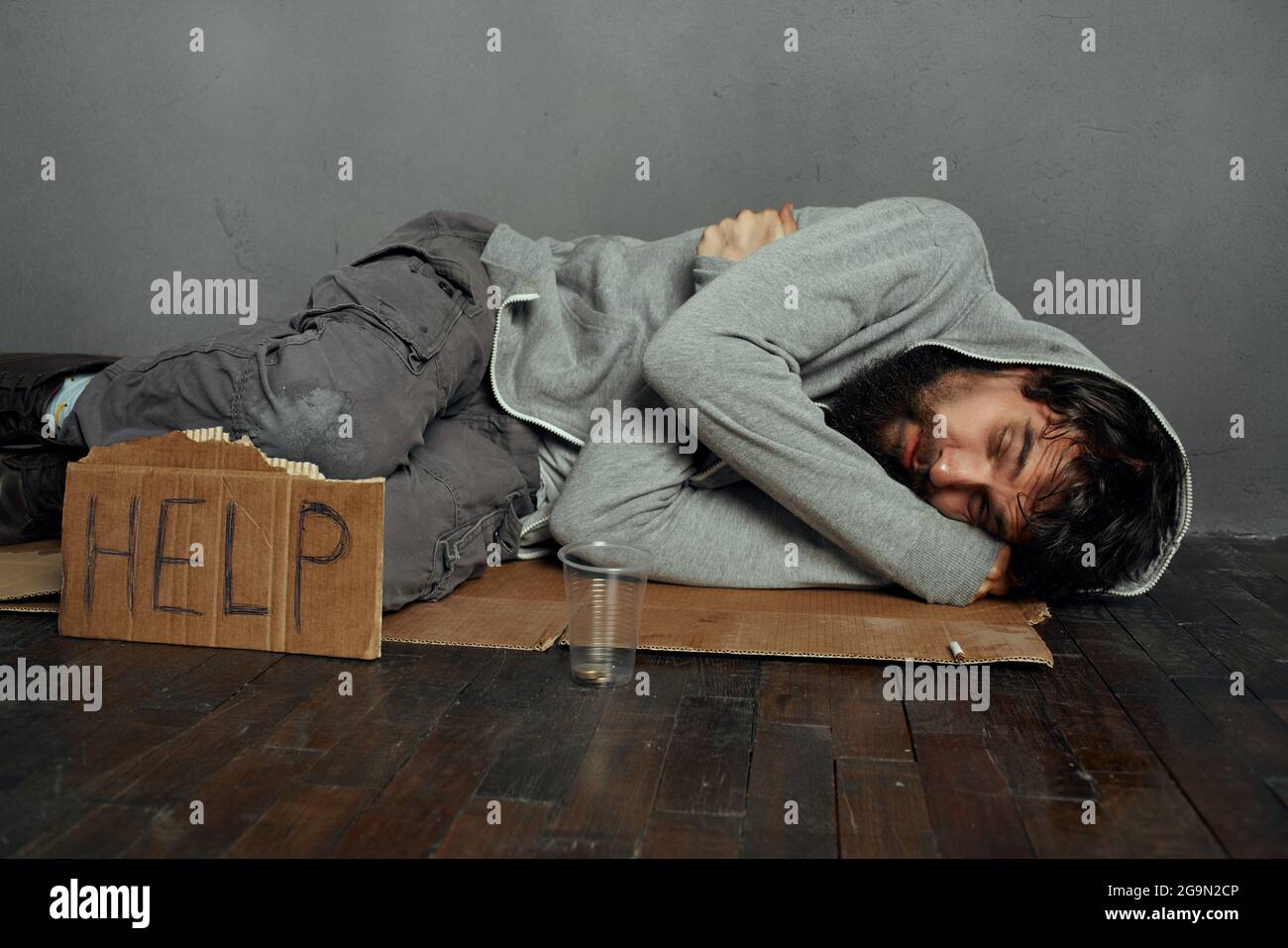 homeless man lying on the floor with a sign help homeless depression ...