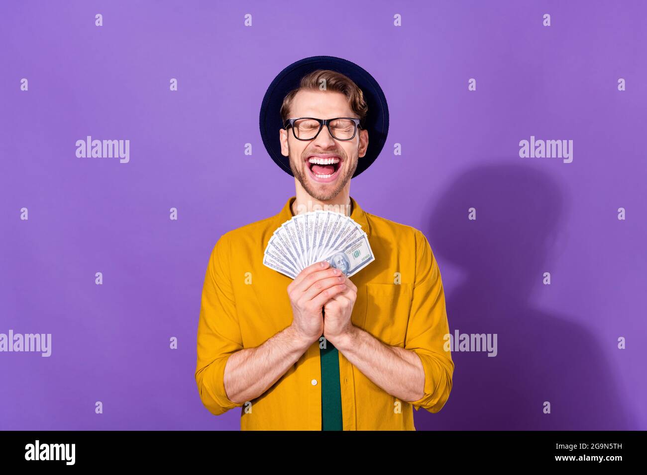 Photo of young excited guy happy positive smile rich dollars banknotes ...