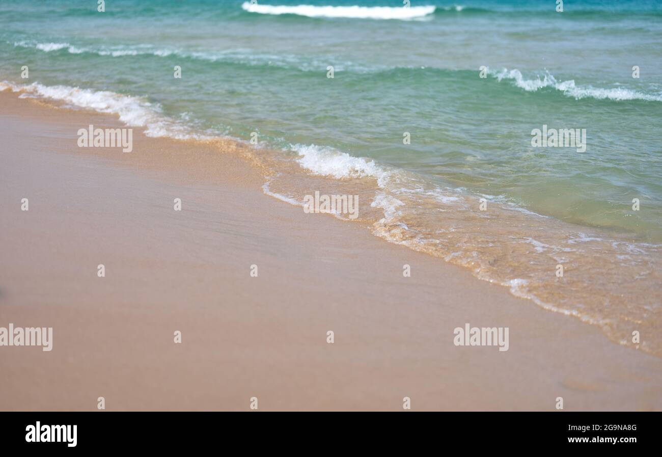 detail of a wet sandy beach with waves in a turquoise blue sea Stock ...