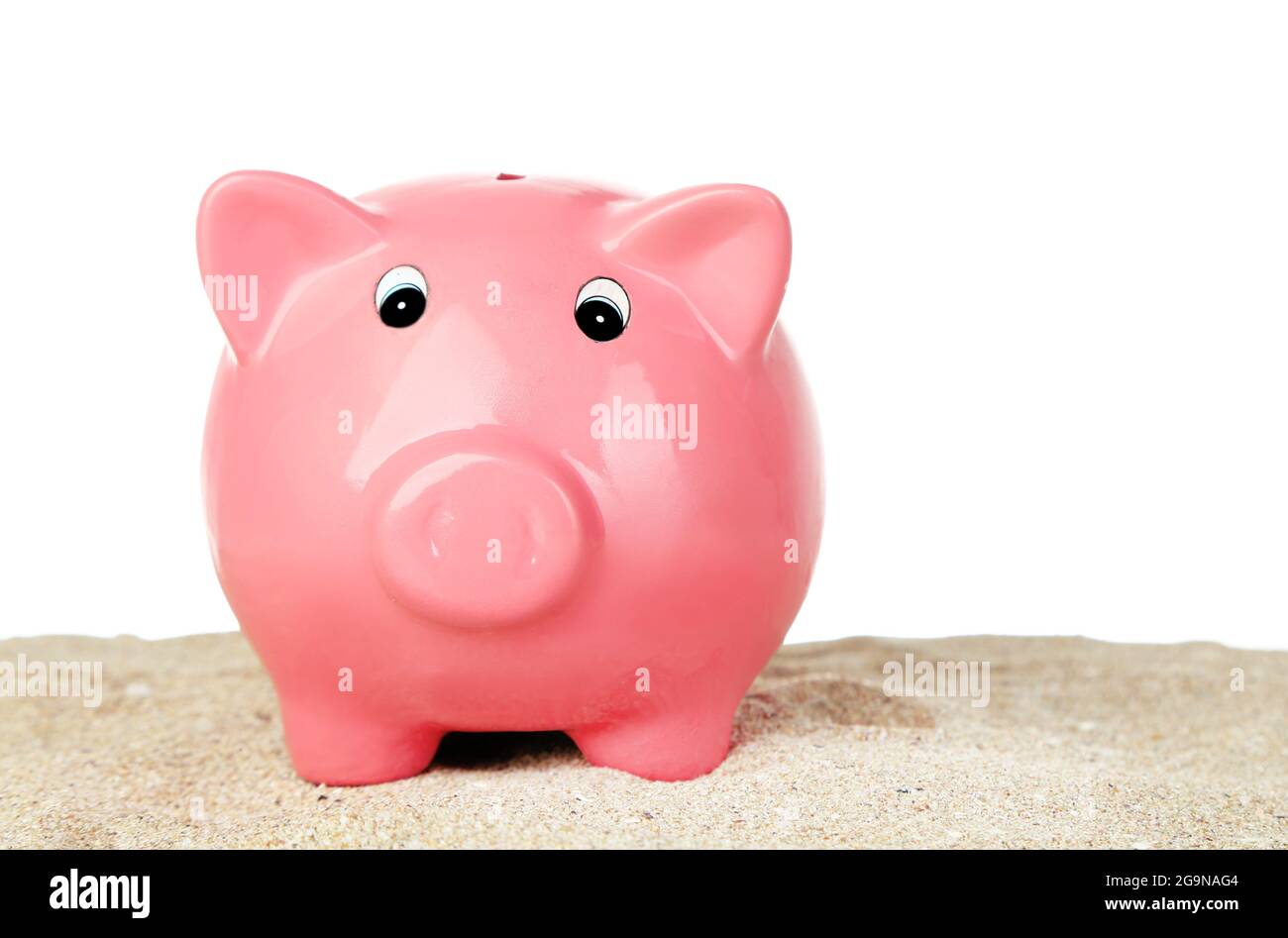 Piggy bank on sand, on white background Stock Photo - Alamy