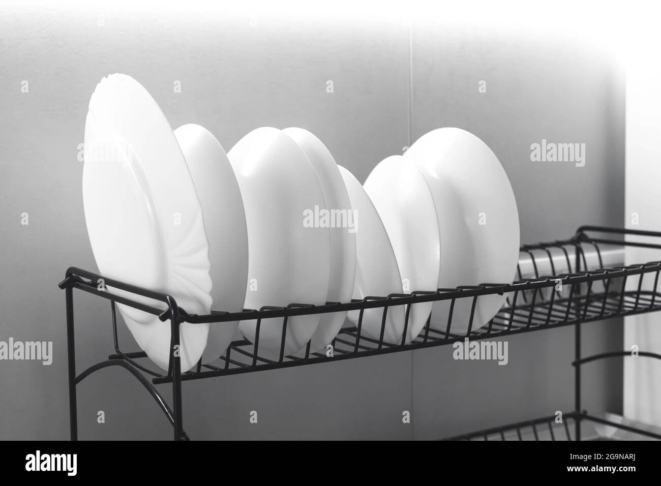 Drying rack with clean white dishes on table in modern kitchen interior ...
