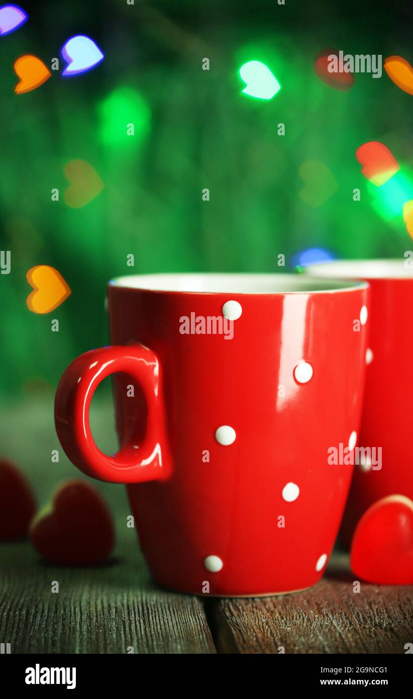 Two red cups on table on lights background Stock Photo - Alamy