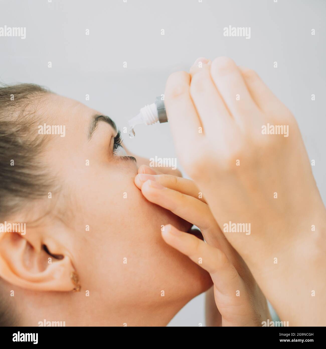 Young girl buries her eyes with special eye drops Stock Photo - Alamy