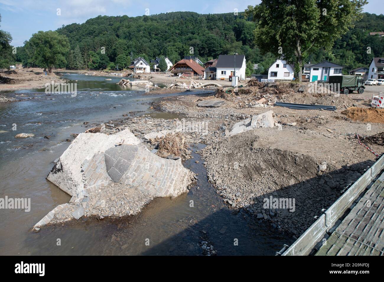 Insul, Germany. 27th July, 2021. Remains of the arched bridge swept away by the flood lie in the ...