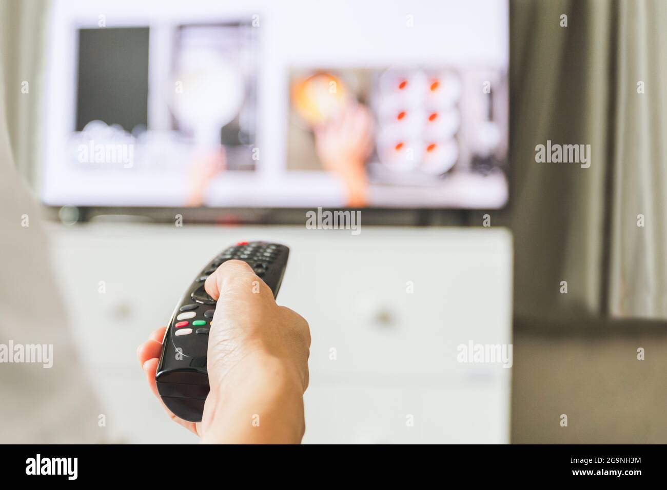 Close up hand holding television remote control Stock Photo - Alamy
