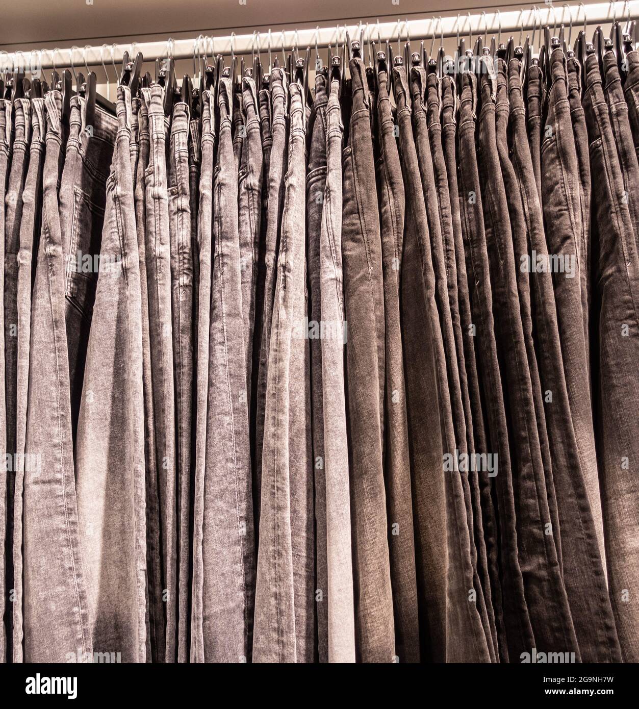 Denim jeans on rack in clothes store Stock Photo - Alamy