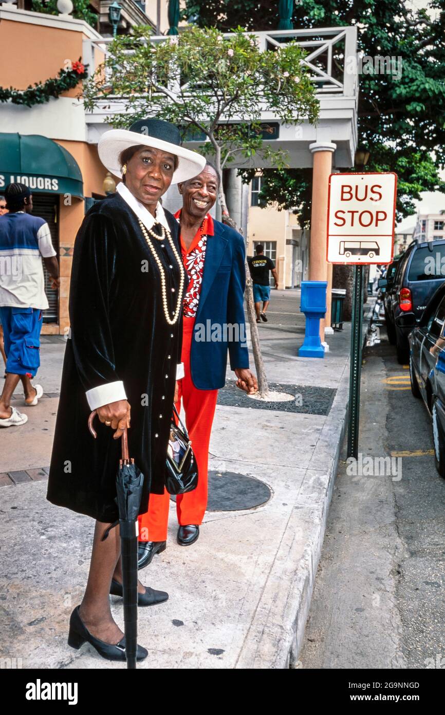Bahamian husband and wife waiting at bus stop to go to Sunday mass ...
