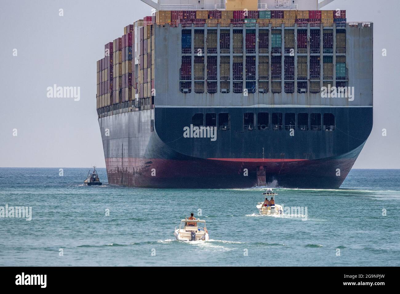 Big Container ship near the coast with tugboat and small vessels Stock ...