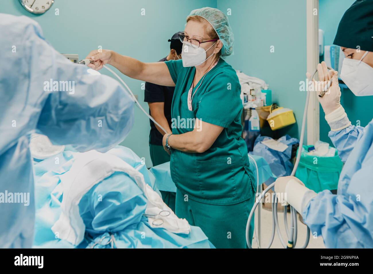 Medical doctors preparing patient in operating room at modern hospital ...