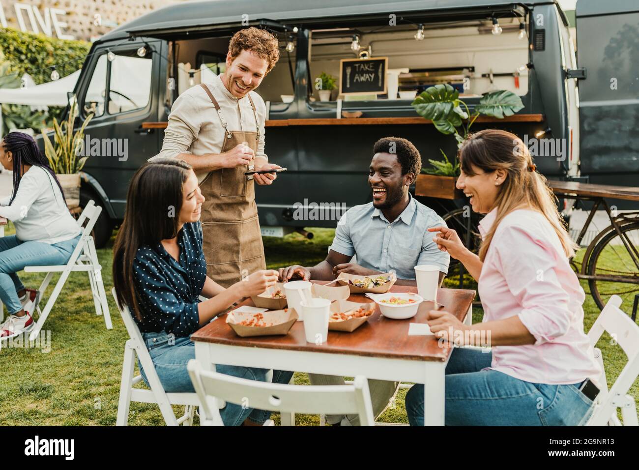 Friendly waiter taking order from diverse friends near food truck Stock ...